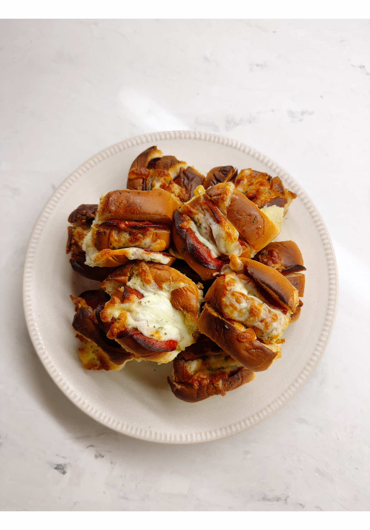 Making baked cheesy pepperoni pizza sliders, a crowd pleasing snack ...